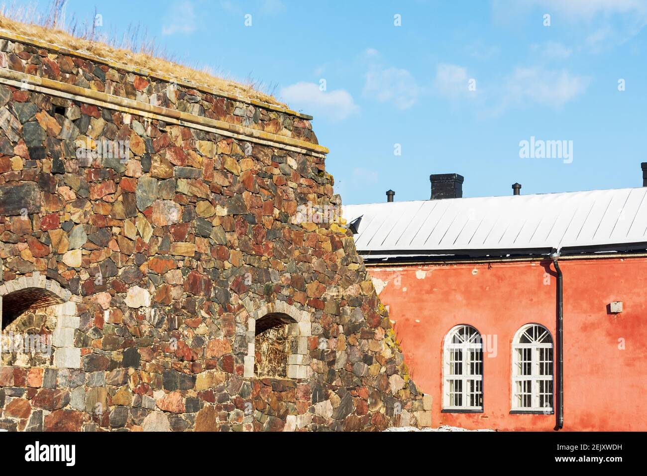 Old stone wall and a red building on Suomenlinna fortress island in ...