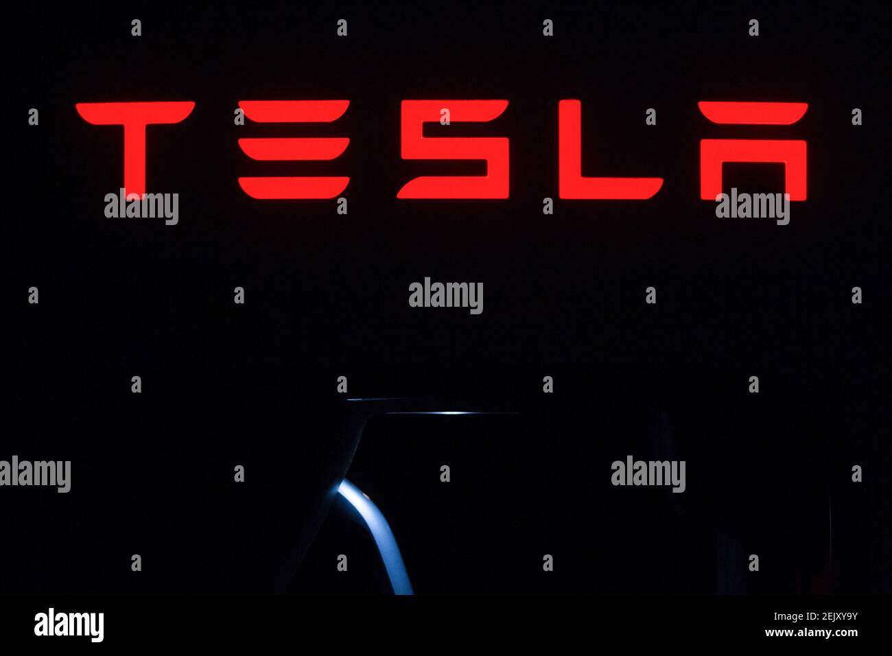 In this photo illustration, the Tesla logo seen on a Supercharger rapid ...