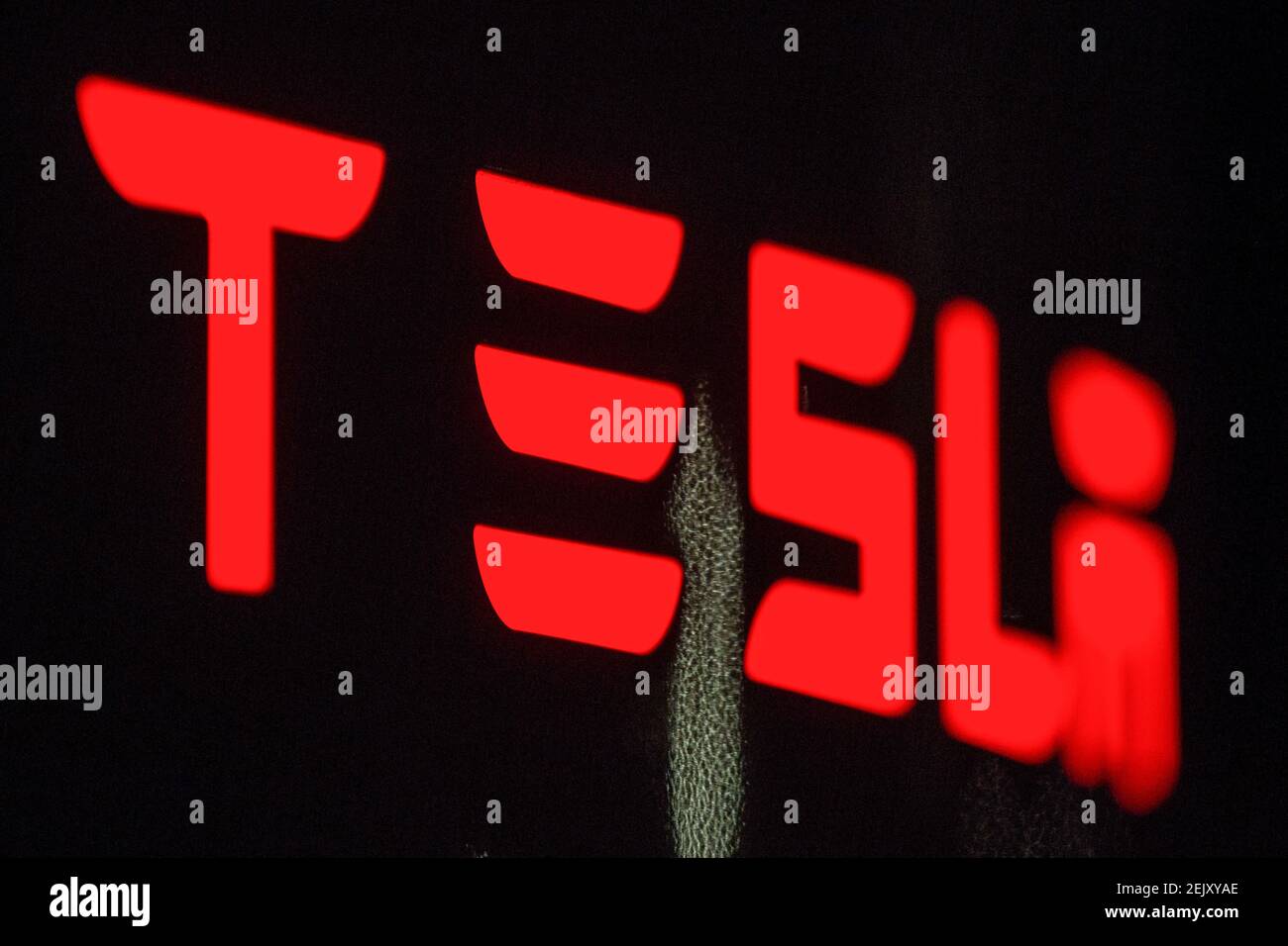 In this photo illustration, the Tesla logo seen on a Supercharger rapid ...