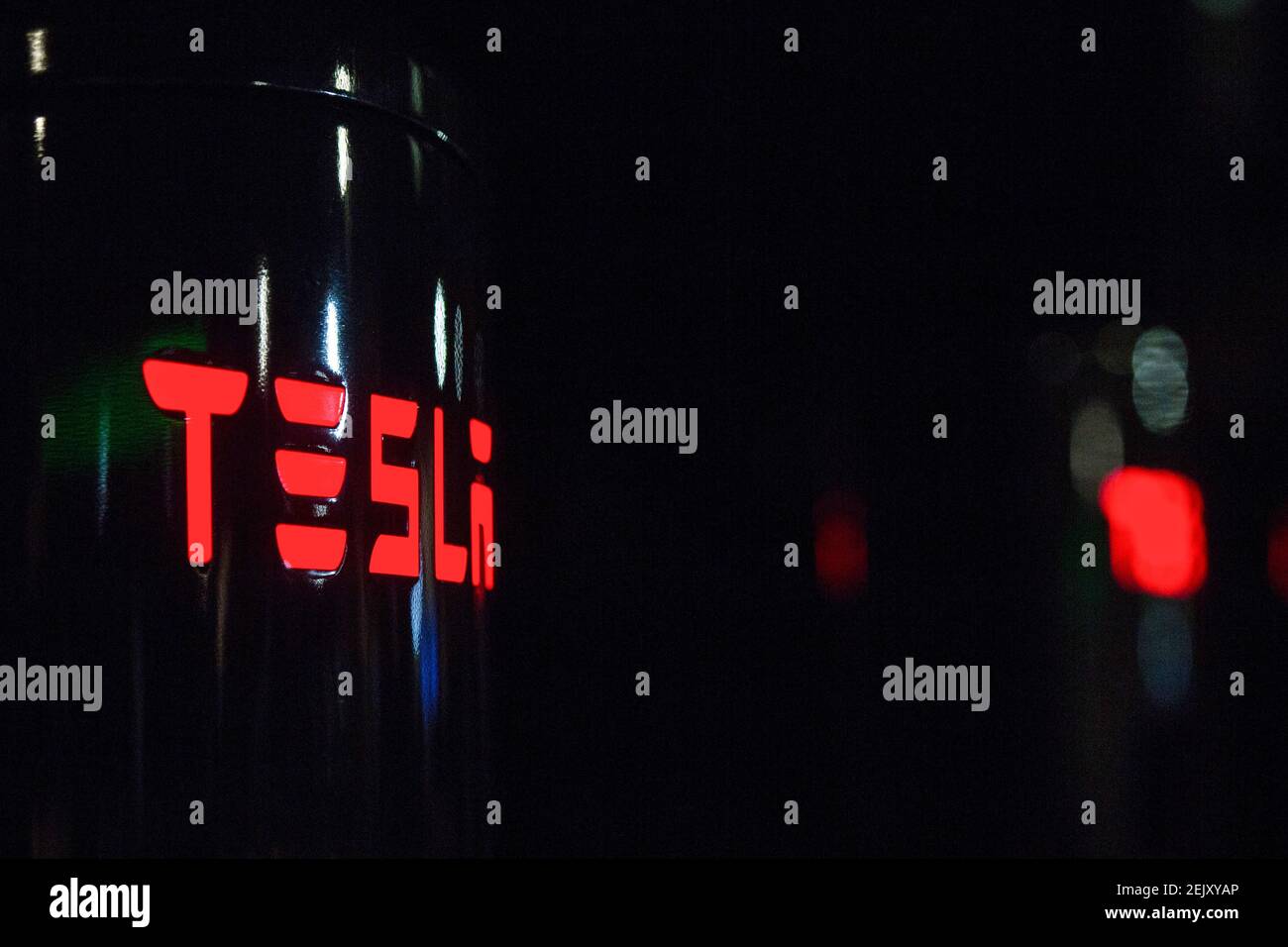 In this photo illustration, the Tesla logo seen on a Supercharger rapid ...