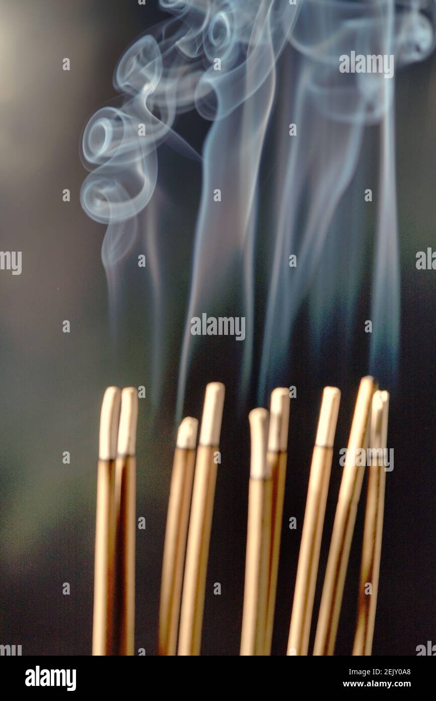 Burning incense, white smoke, black background, used as a worship ...