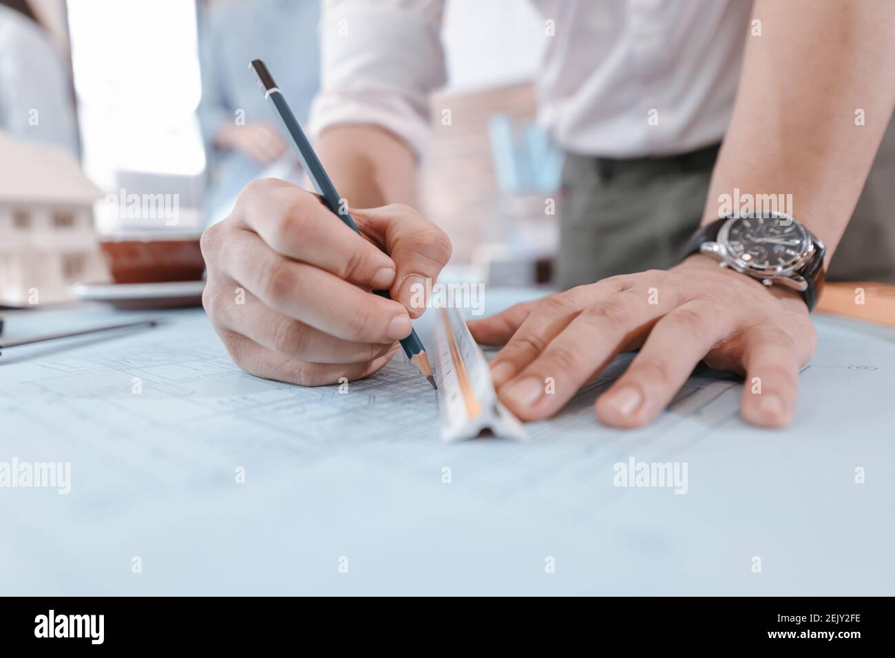 engineers holding a pen pointing to a building and drawing outlay ...