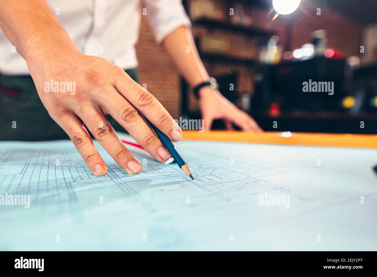 engineers holding a pen pointing to a building and drawing outlay ...