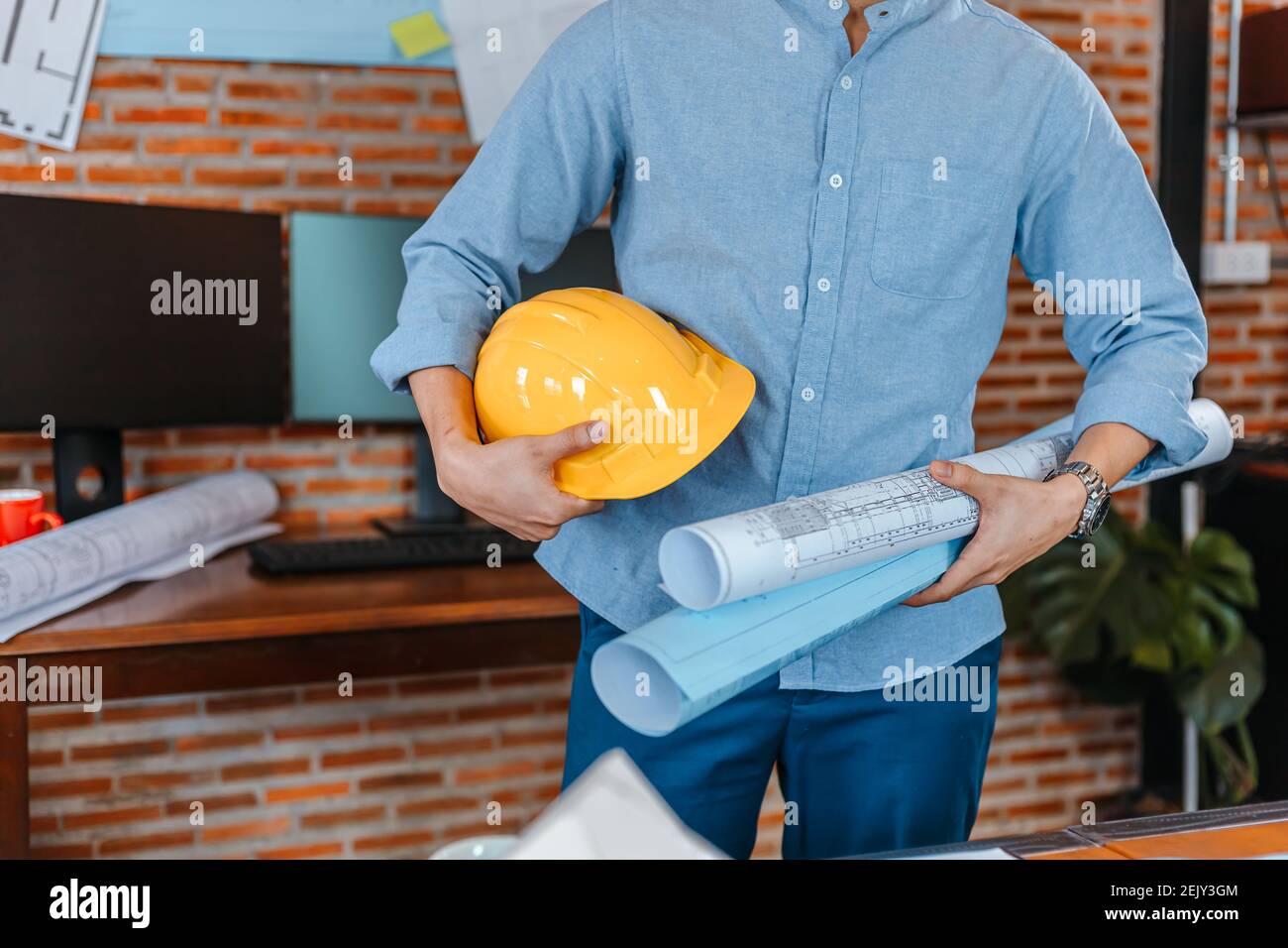 engineer hold engineer drawing design blueprints and safety helmet in ...