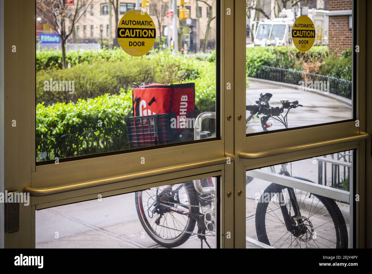 A delivery bicycle with a GrubHub branded tote outside an apartment ...