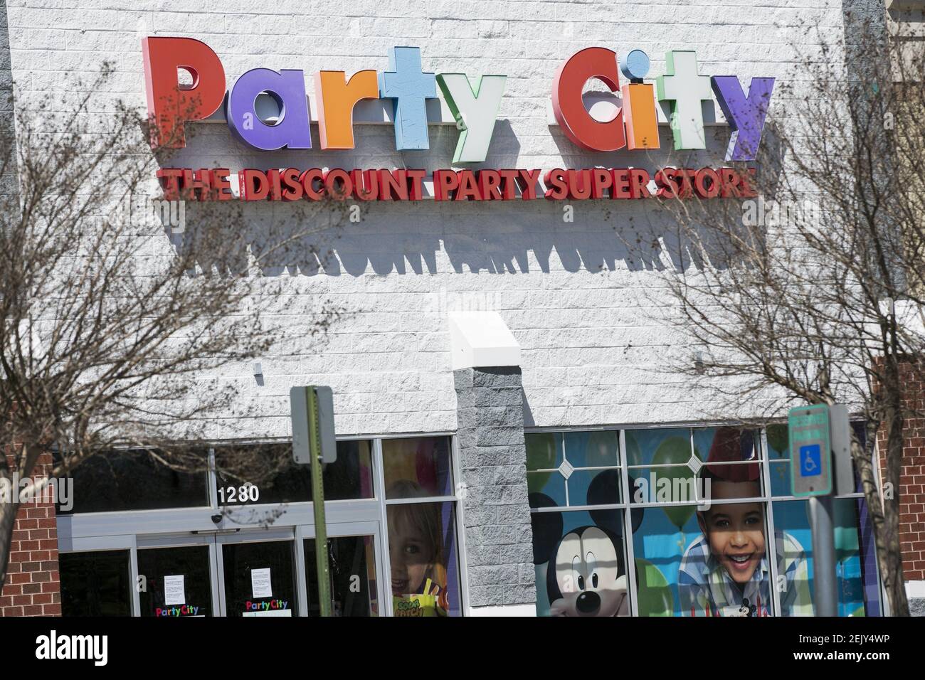 A logo sign outside of a Party City retail store location in ...
