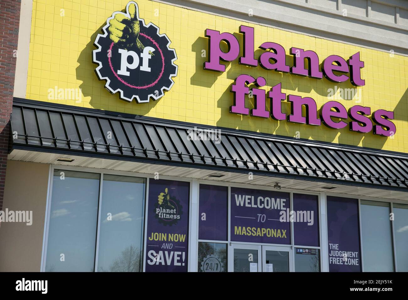 A logo sign outside of a Planet Fitness location in Fredericksburg ...