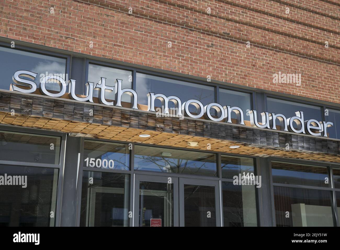A logo sign outside of a South Moon Under retail store location in ...