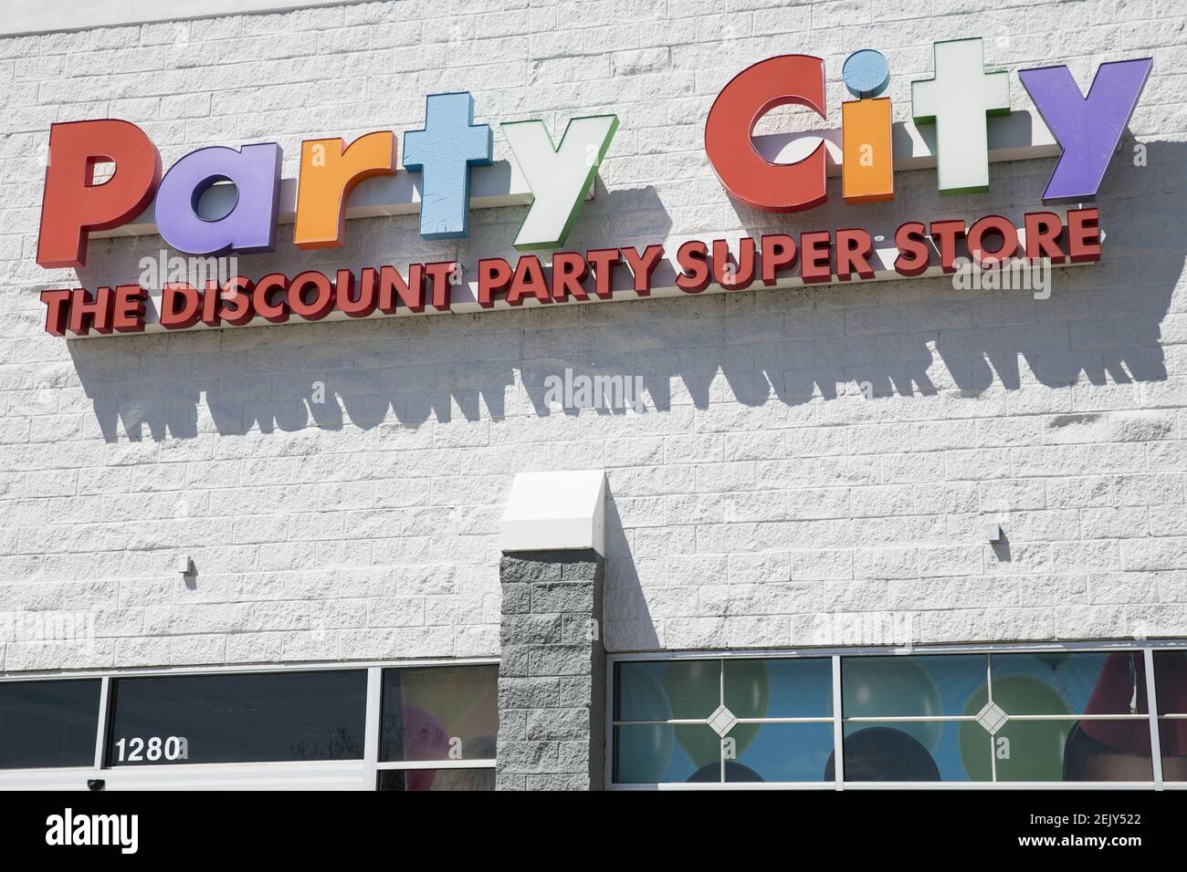 A logo sign outside of a Party City retail store location in ...