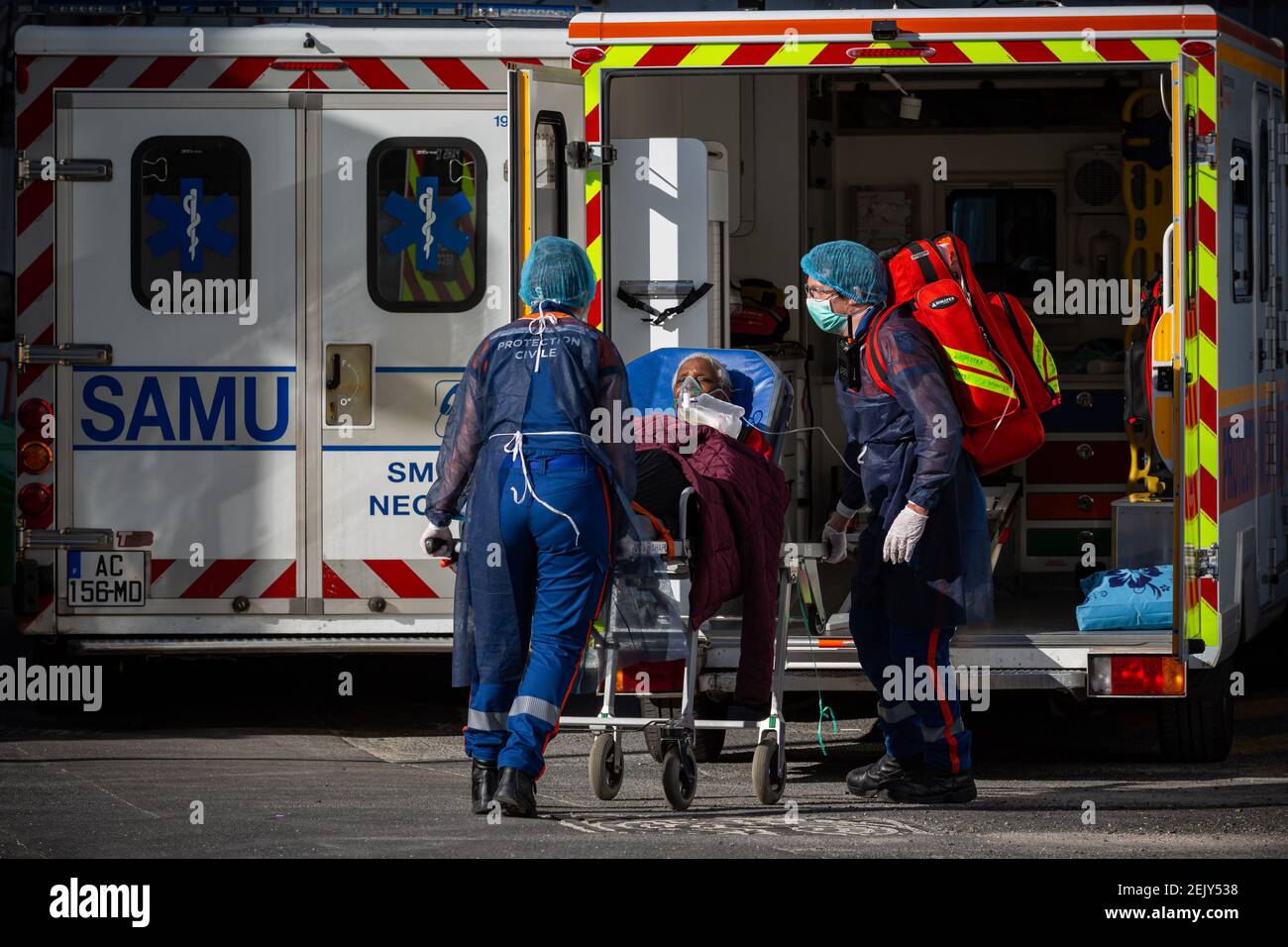 Two paramedics bring a patient into the emergency room of the ...