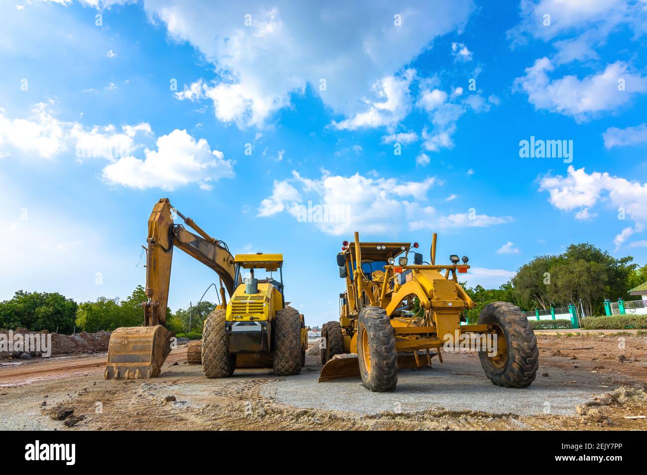 Backhoe, grader and road roller on the ground at site construction ...
