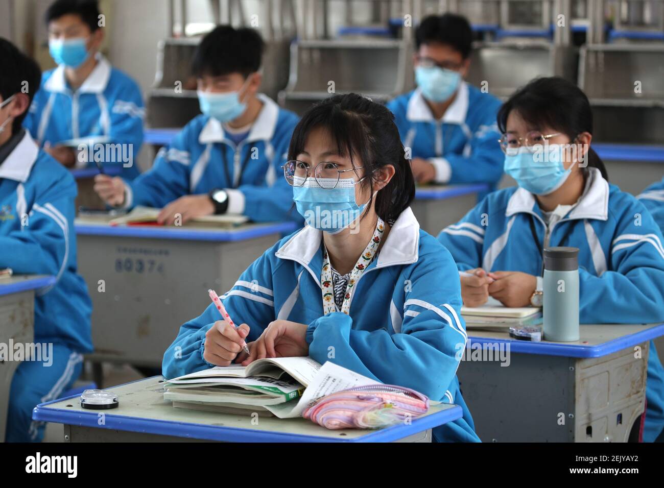Students with face mask on take classes at classroom after a two-and ...