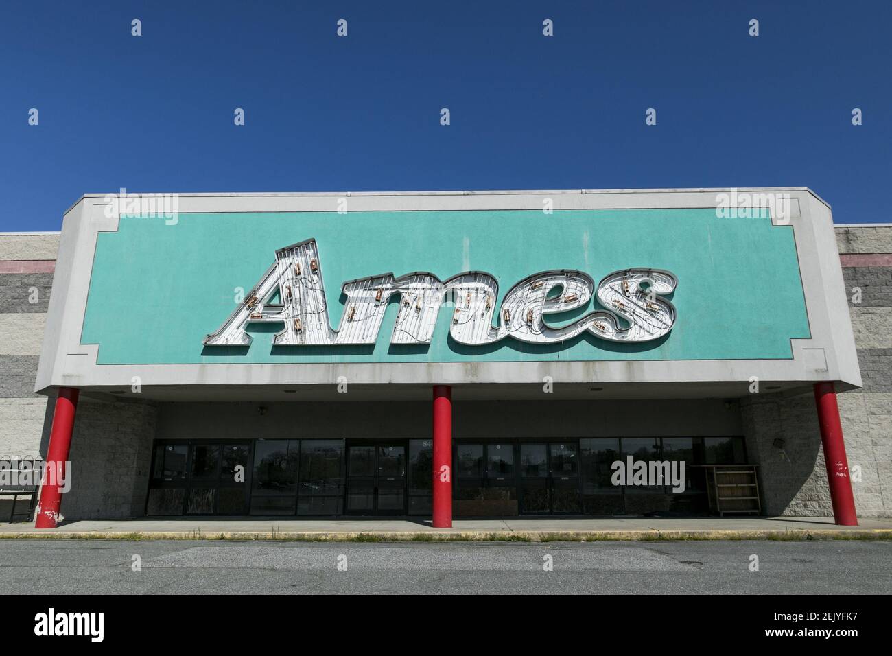 A logo sign outside of a closed and abandoned Ames Department Stores ...