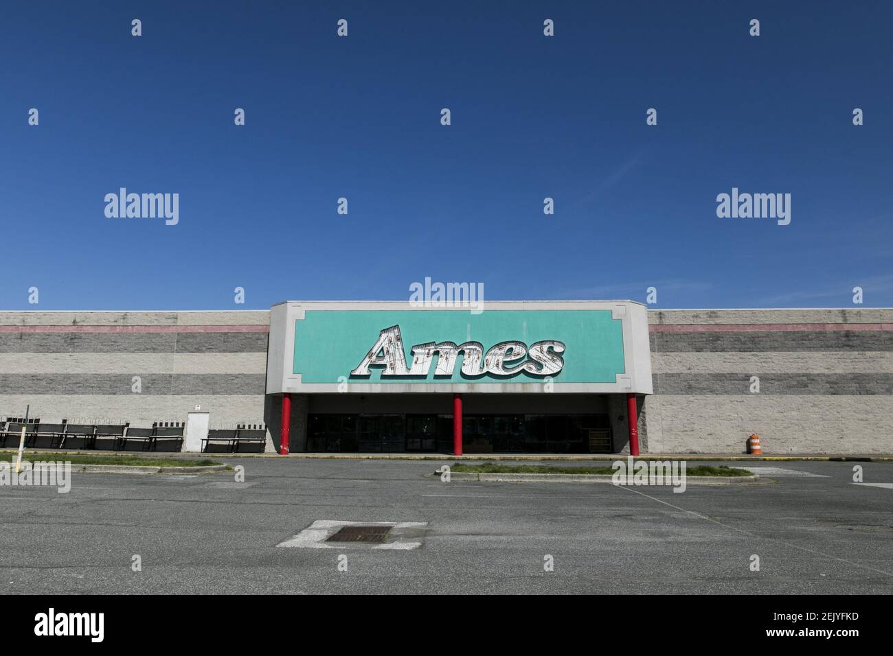 A logo sign outside of a closed and abandoned Ames Department Stores ...