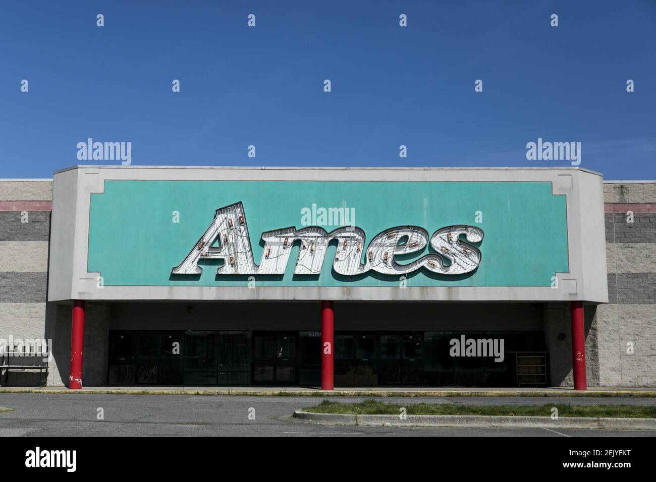 A logo sign outside of a closed and abandoned Ames Department Stores ...