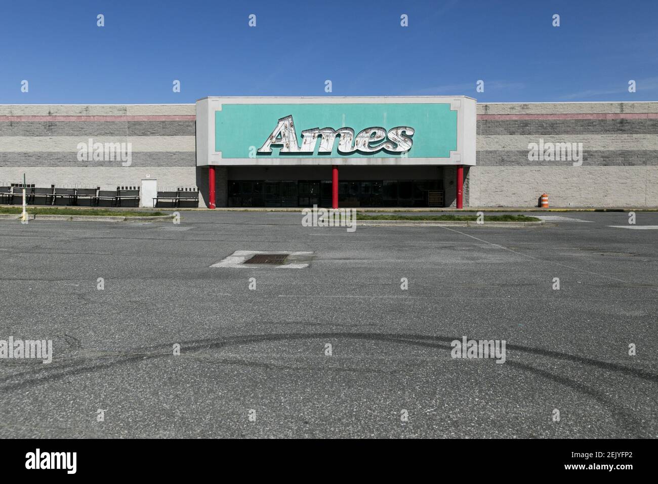 A logo sign outside of a closed and abandoned Ames Department Stores ...