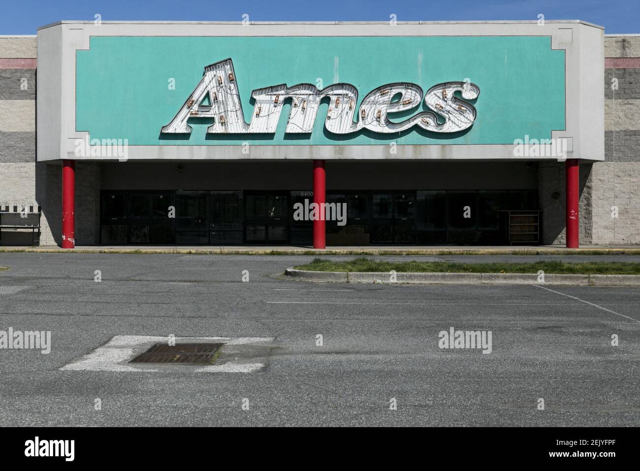 A logo sign outside of a closed and abandoned Ames Department Stores ...