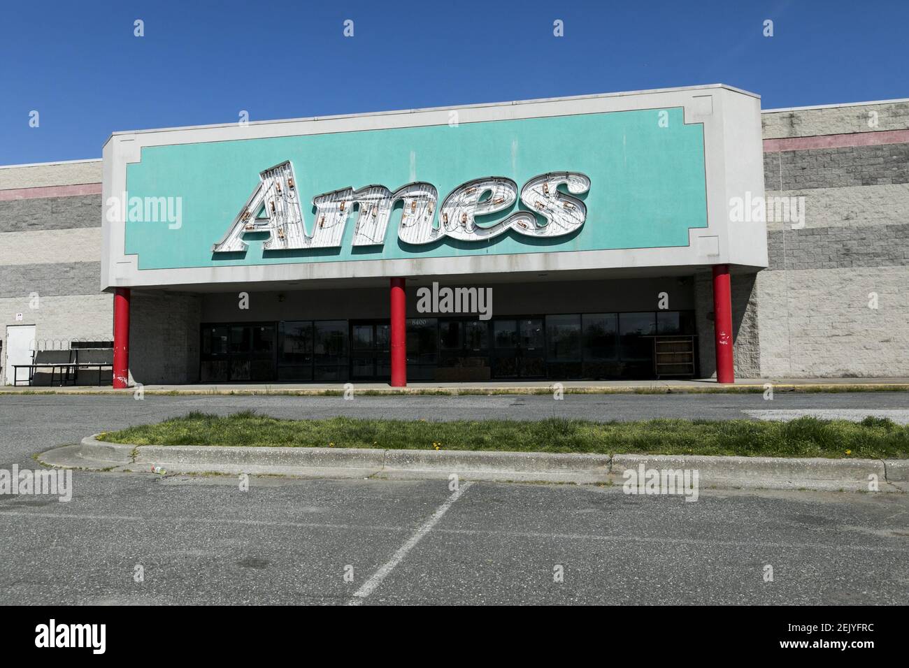 A logo sign outside of a closed and abandoned Ames Department Stores ...