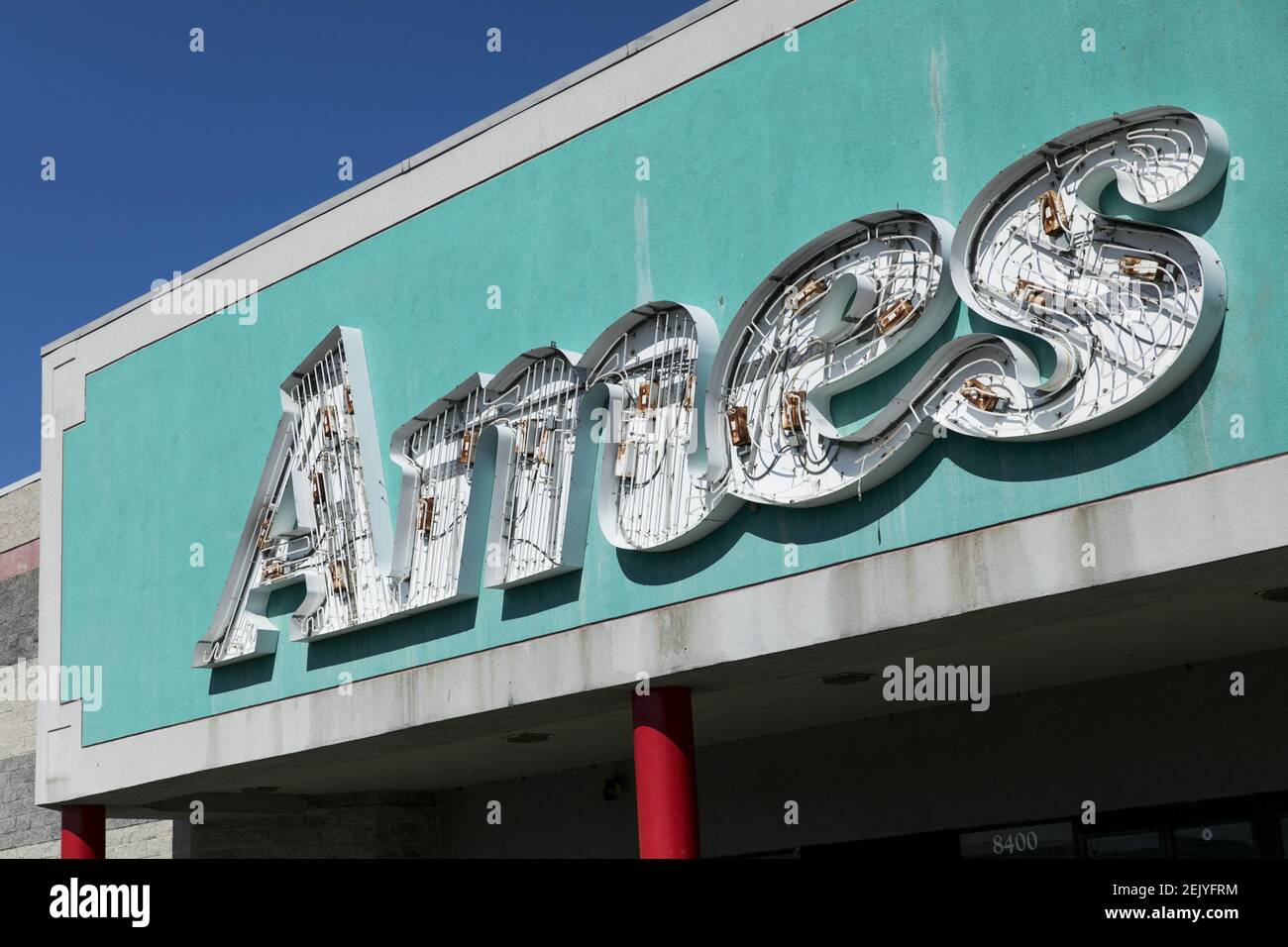 A logo sign outside of a closed and abandoned Ames Department Stores ...