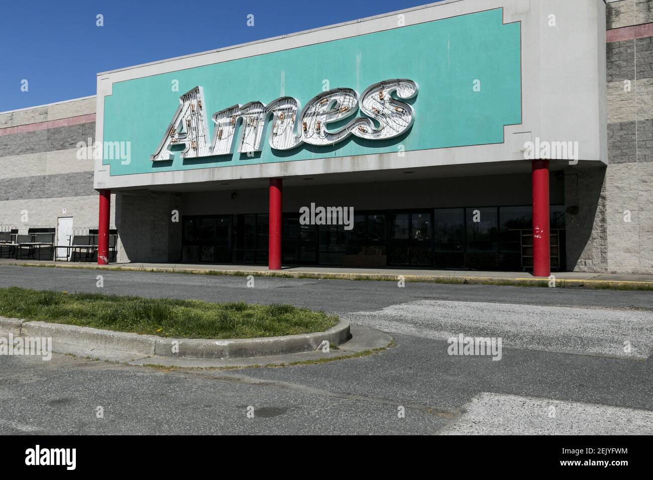 A logo sign outside of a closed and abandoned Ames Department Stores ...