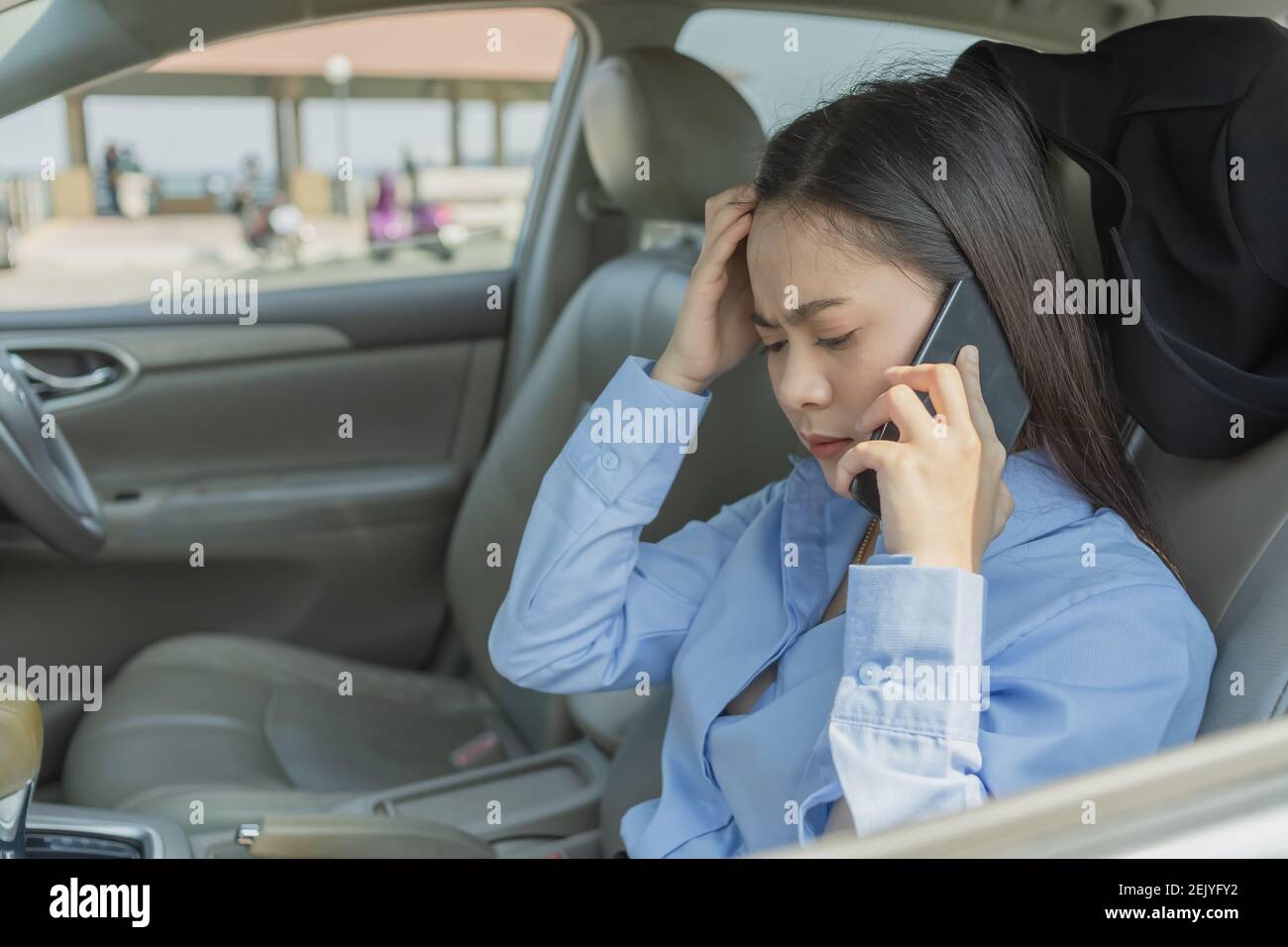 Businesswoman inside a car using a mobile phone for working and she is ...
