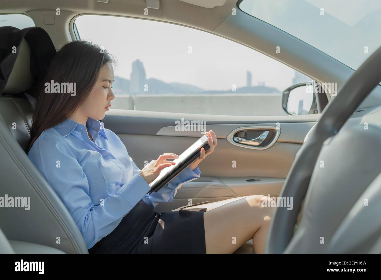 Businesswoman inside a car using a tablet for working Stock Photo - Alamy