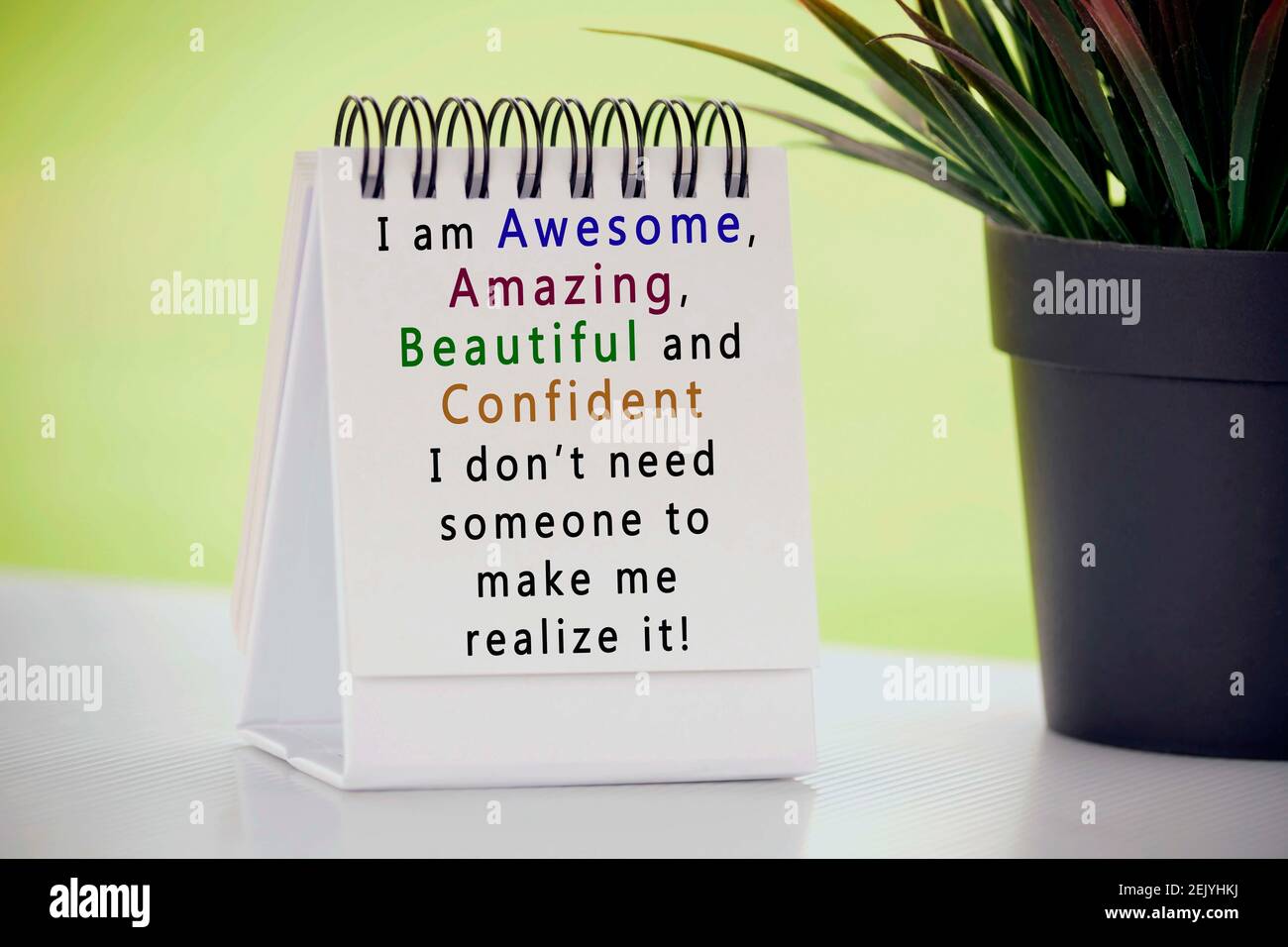 Inspirational quote on paper stand with potted plant and blurred ...