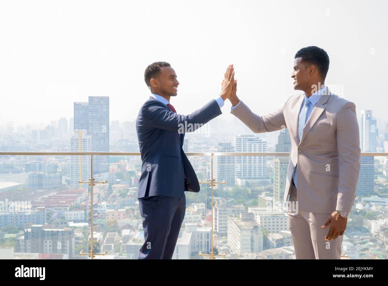 Smiling male friends and high five hi-res stock photography and images ...
