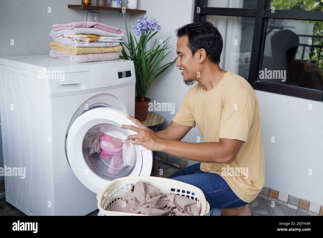 Man smiling loading washing hi-res stock photography and images - Alamy