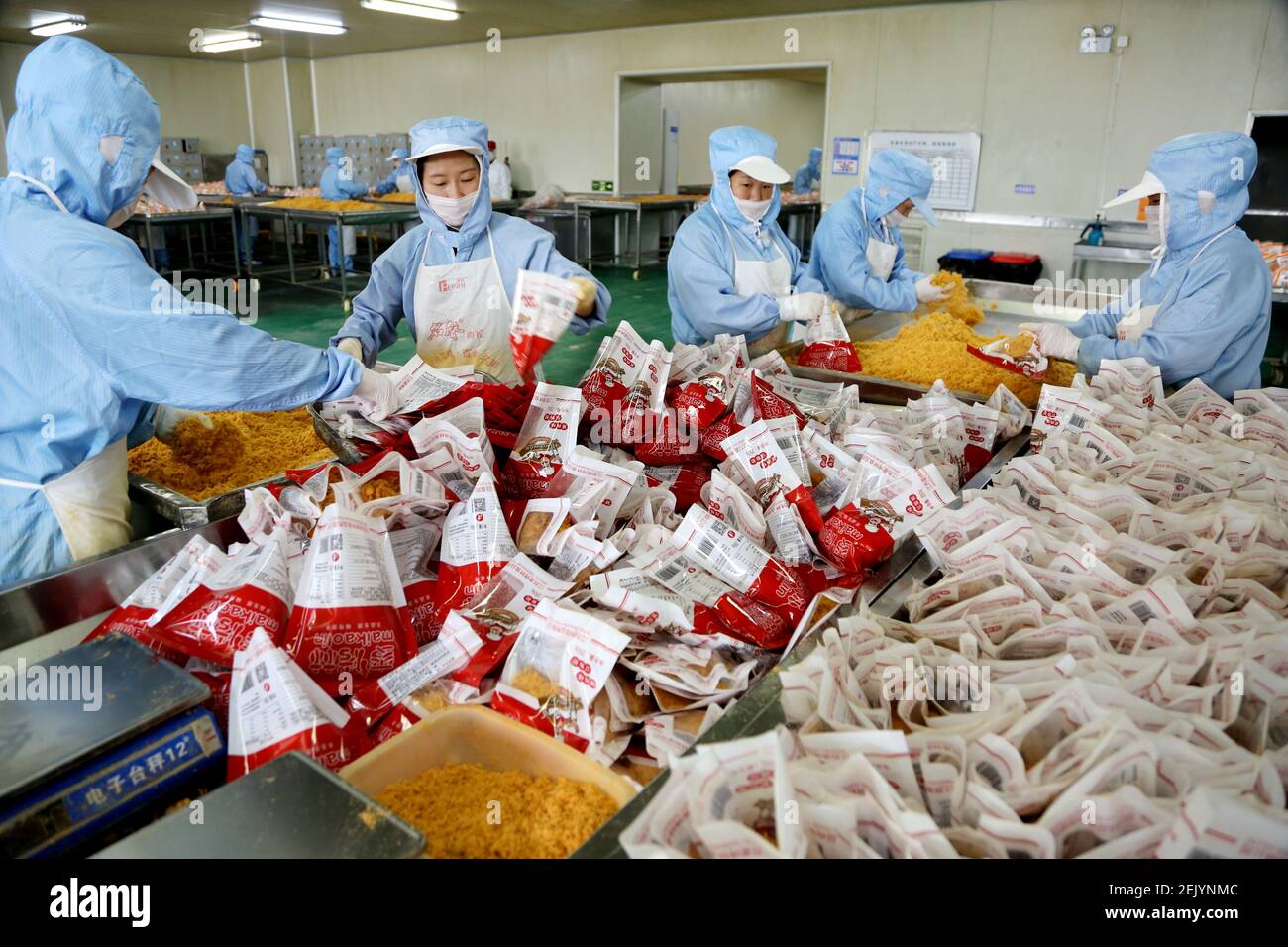Workers work in the workshop of a food processing enterprise to process ...