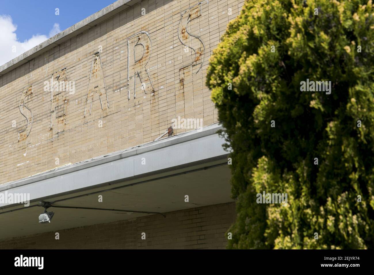 The faded outline of a logo sign outside of a closed and abandoned ...