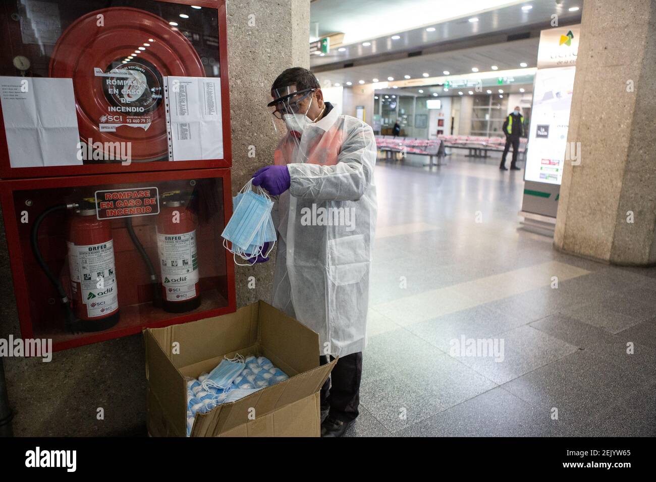 A Spanish Civil Protection member preparing to distribute face masks as ...