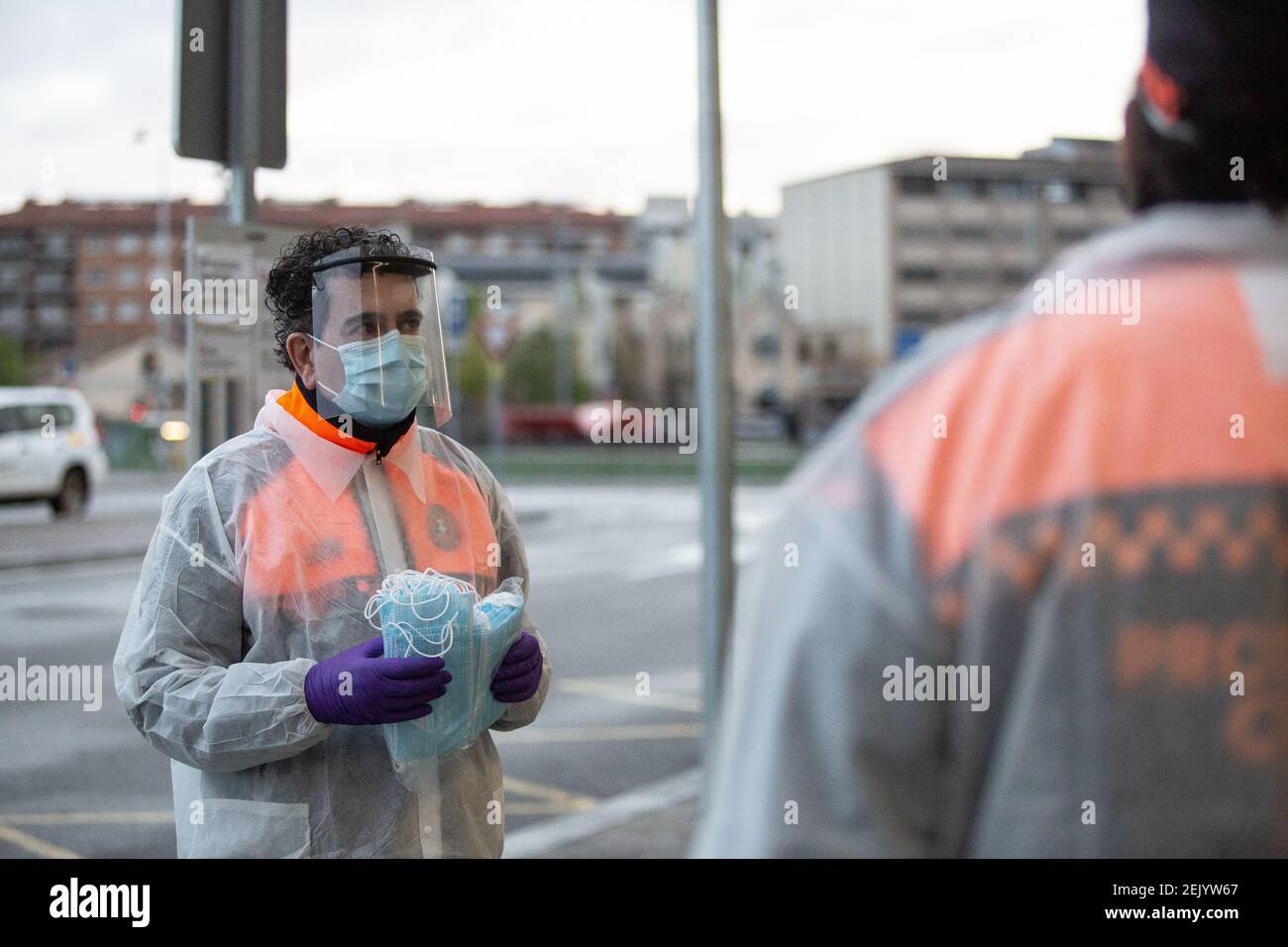 A Spanish Civil Protection member preparing to distribute face masks as ...