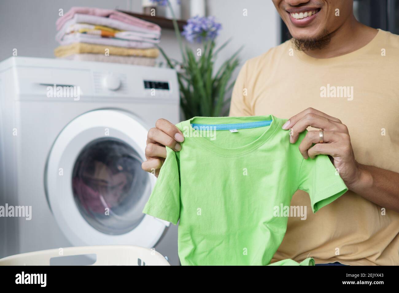 Housework. close up of asian Man doing laundry at home loading clothes ...