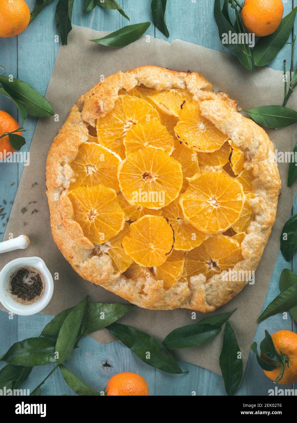 Top view of caraway and orange tart on baking paper over gray wooden ...