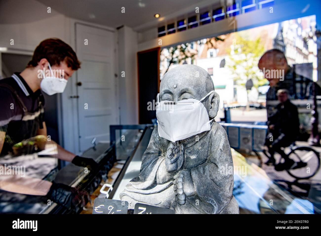 A sculpture wearing a face mask as a display at the store. Opening a ...