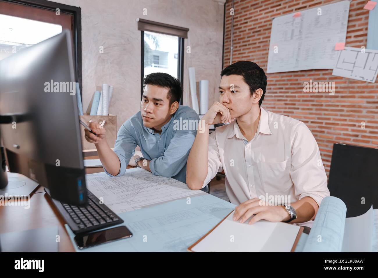 engineers and architect reading a building and drawing outlay ...