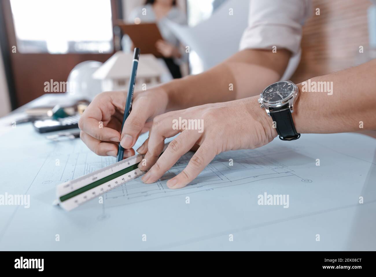 engineers holding a pen pointing to a building and drawing outlay ...