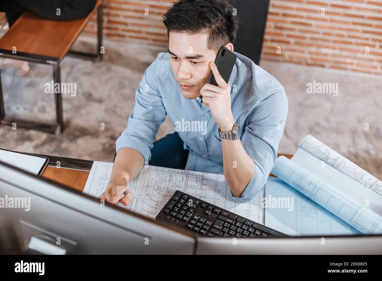 architect use mobile phone call with enginner and reading a building ...