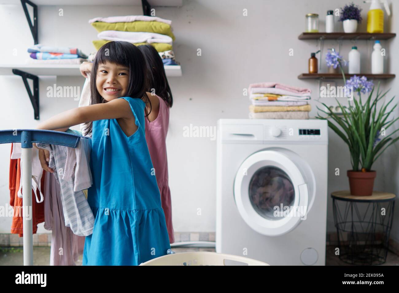 child fun happy little girl to wash clothes and laughs in the laundry ...