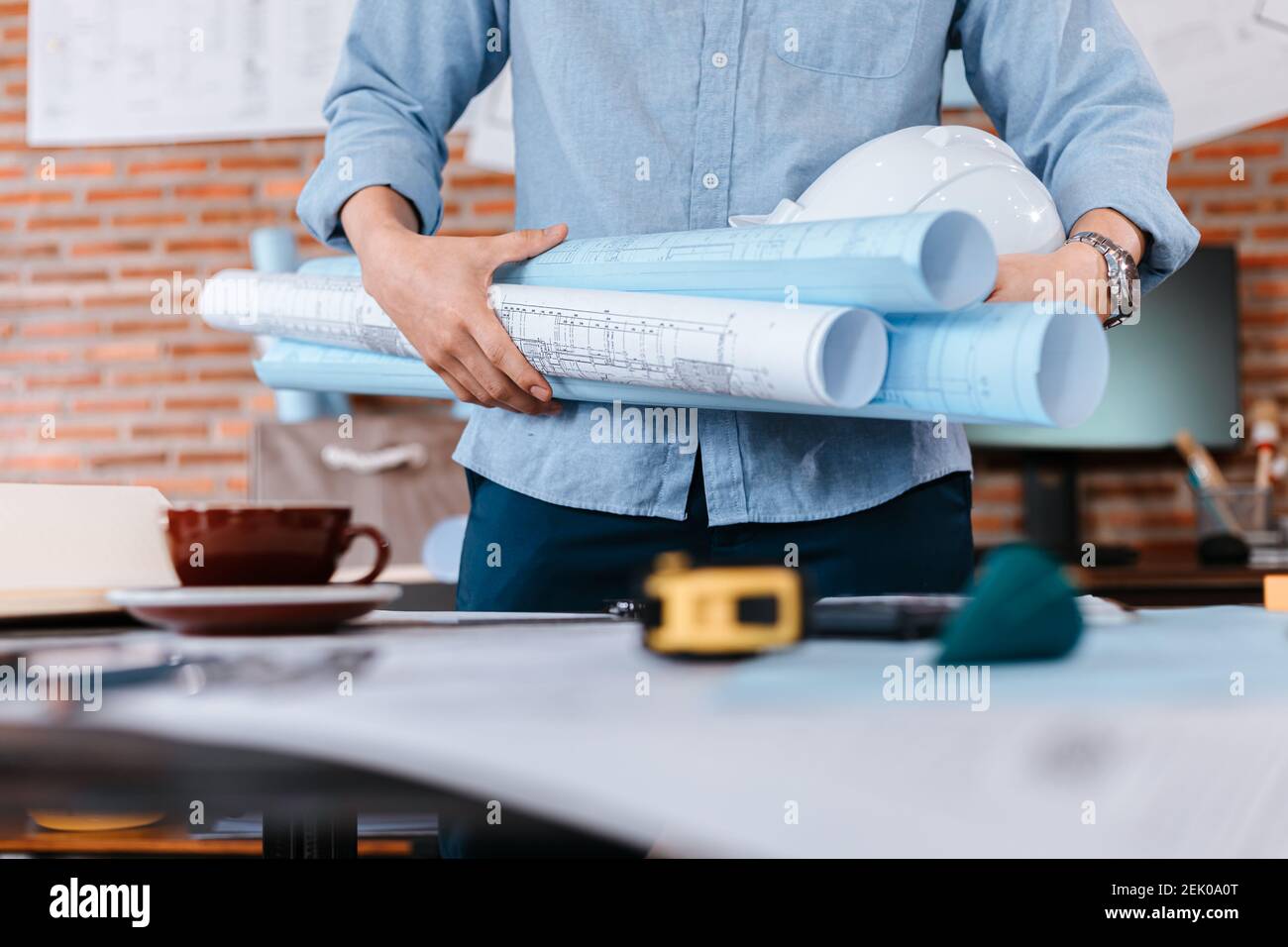 engineer hold engineer drawing design blueprints and safety helmet in ...