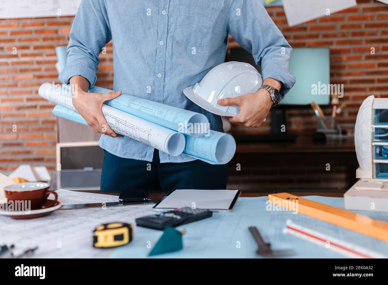 engineer hold engineer drawing design blueprints and safety helmet in ...