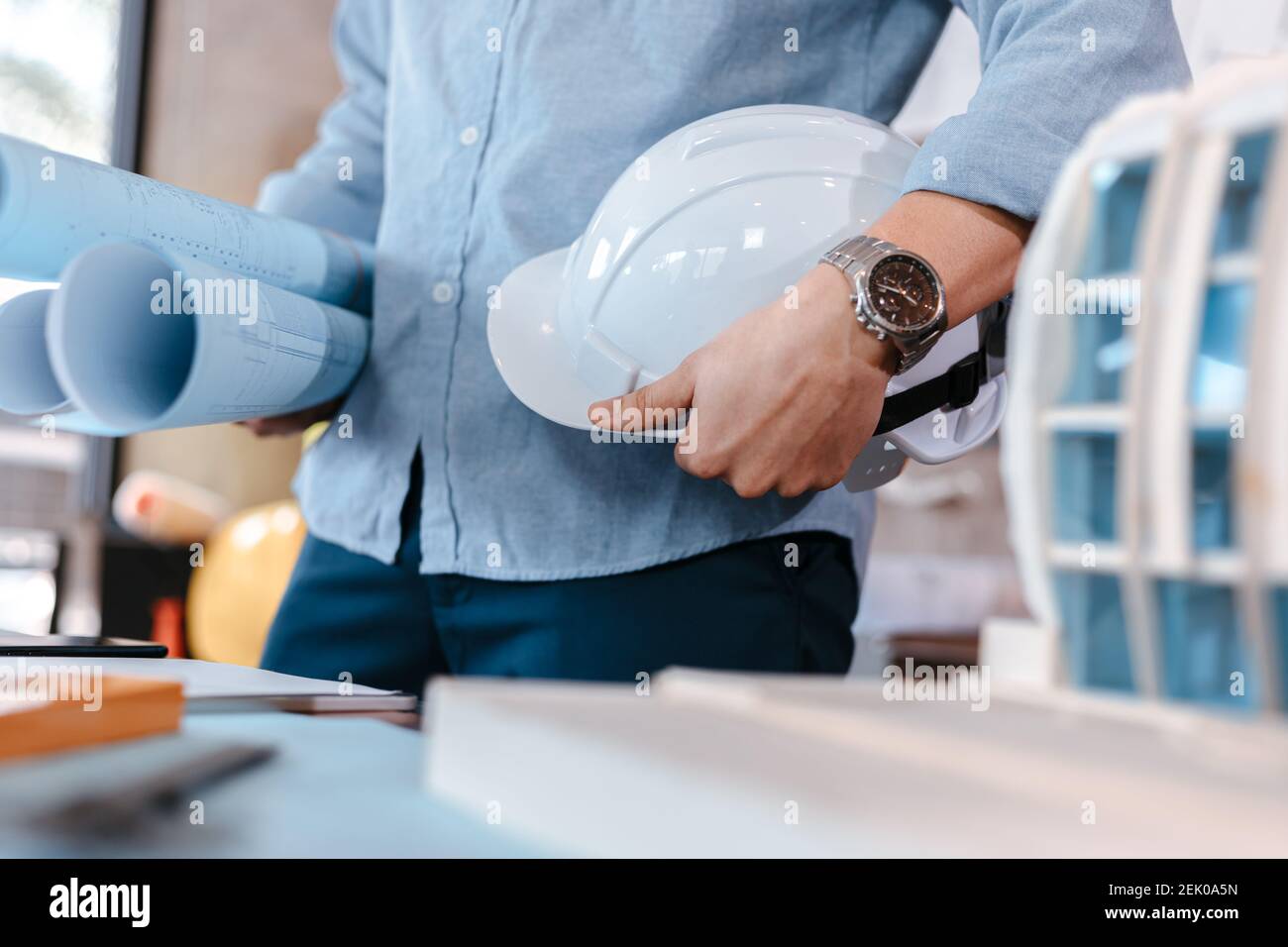 engineer hold engineer drawing design blueprints and safety helmet in ...
