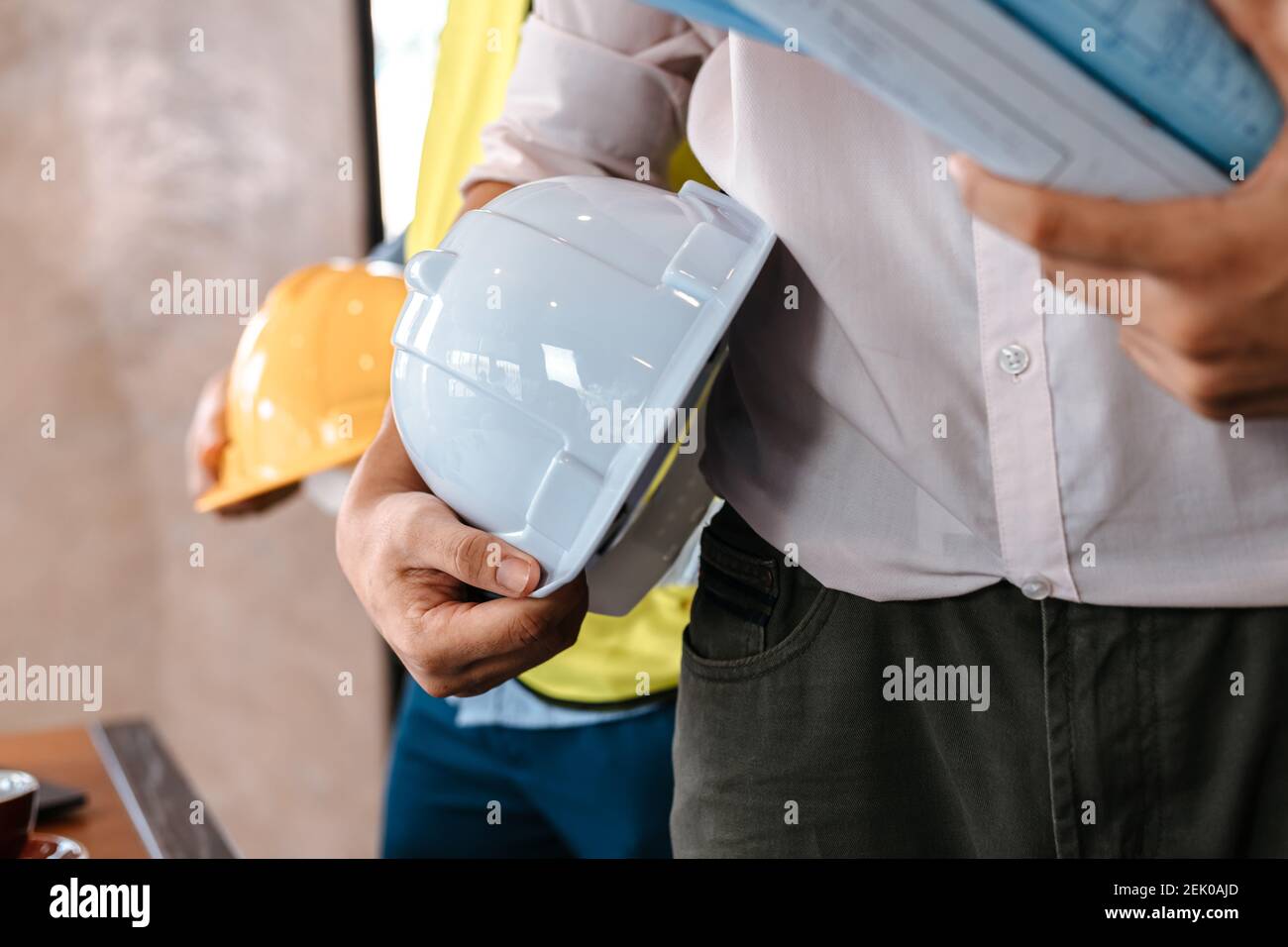 engineer hold engineer drawing design blueprints and safety helmet in ...