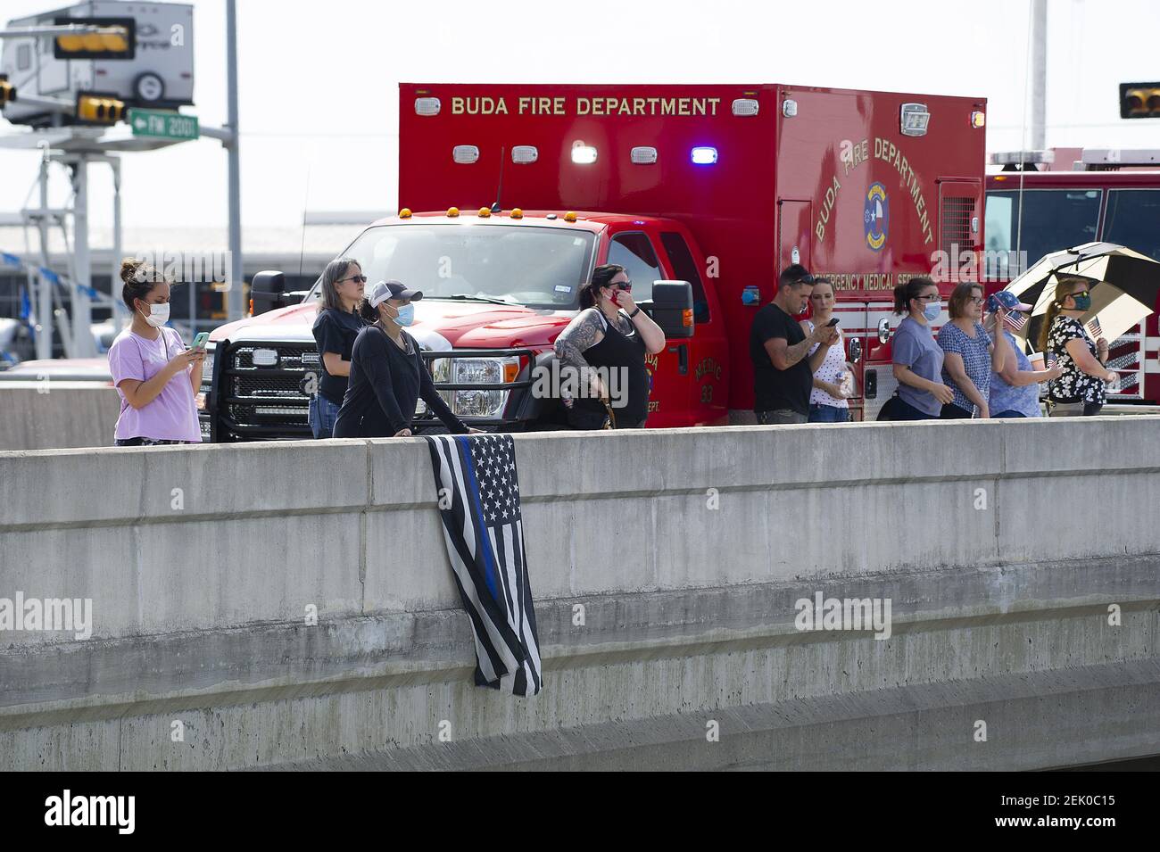 An individual displays the Thin Blue Line American Flag during the procession honoring fallen ...