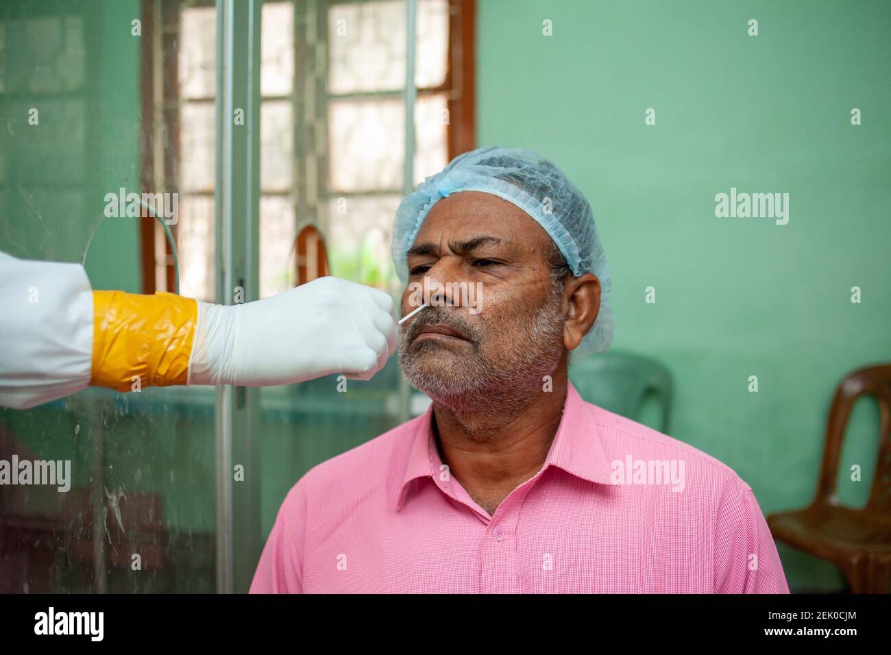A health worker takes a nasal swab test from a suspected patient for ...