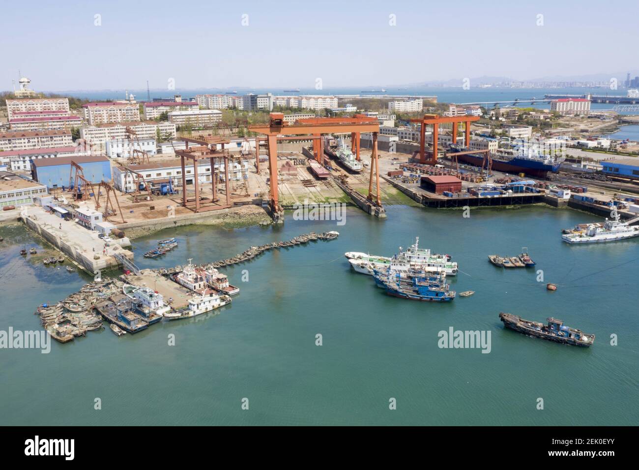 An aerial view of fishing ships either parking at or floating around a ...