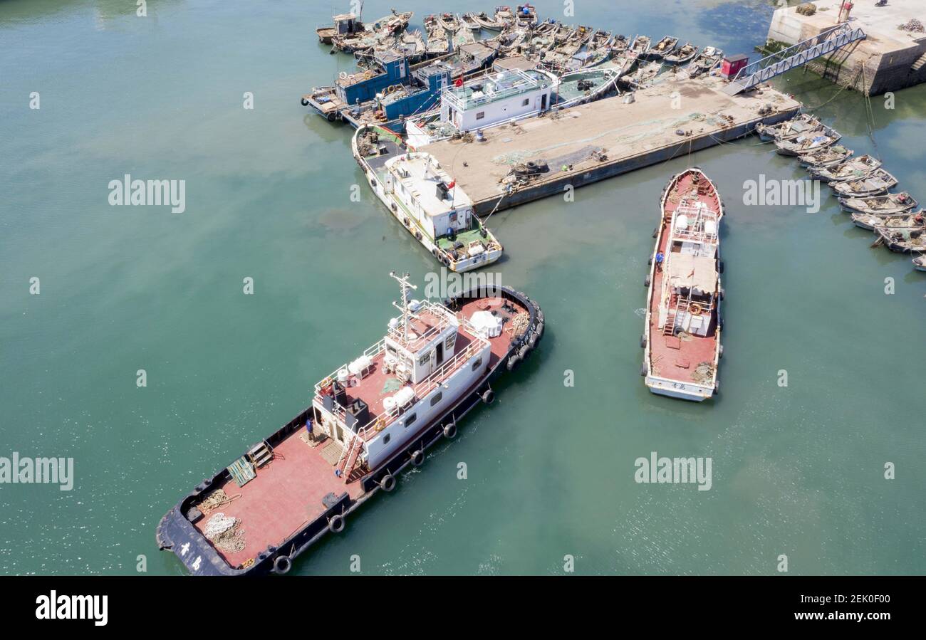 An aerial view of fishing ships either parking at or floating around a ...