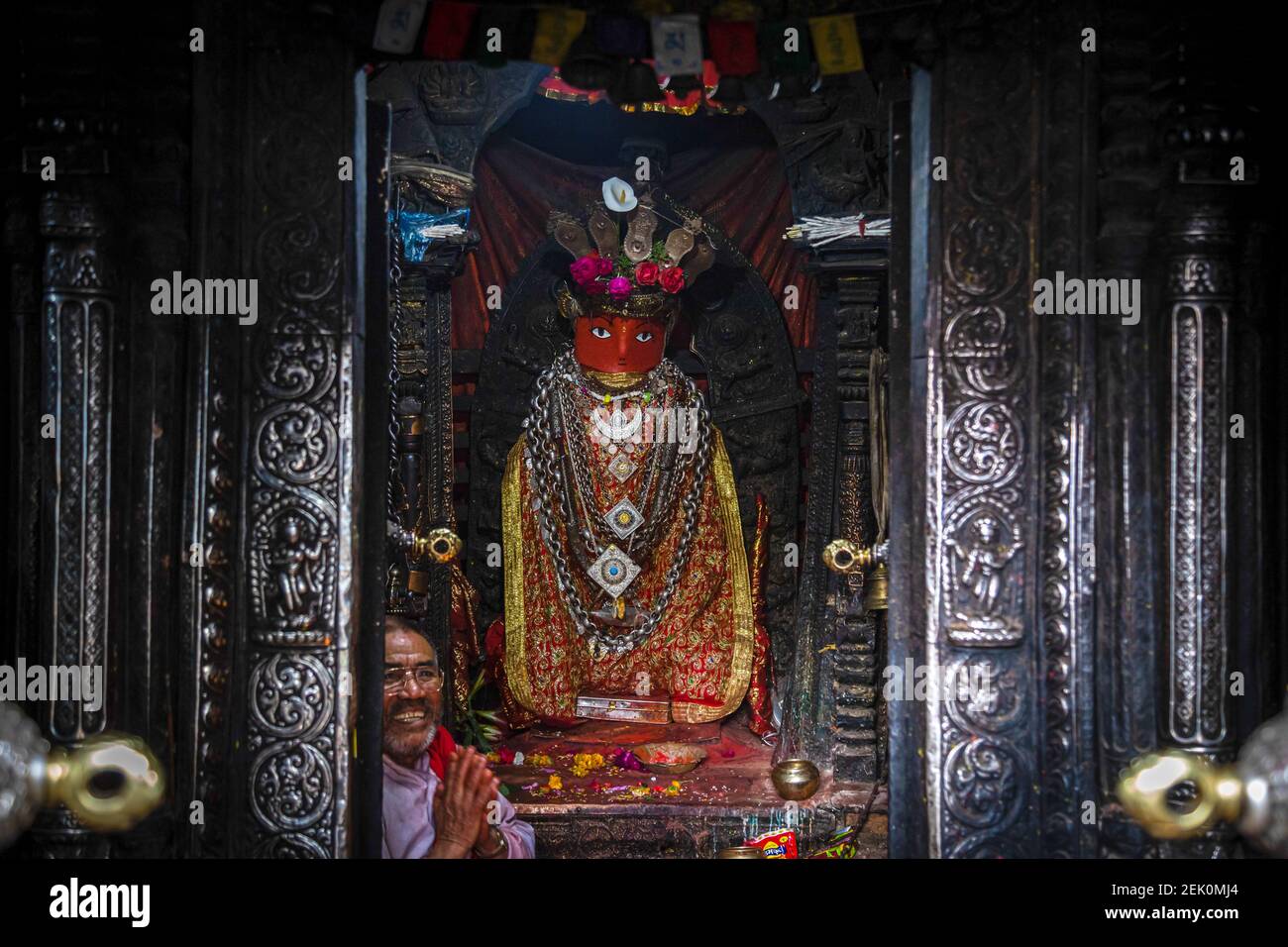 A priest seats next to an idol of deity Rato (Red) Machindranath during ...