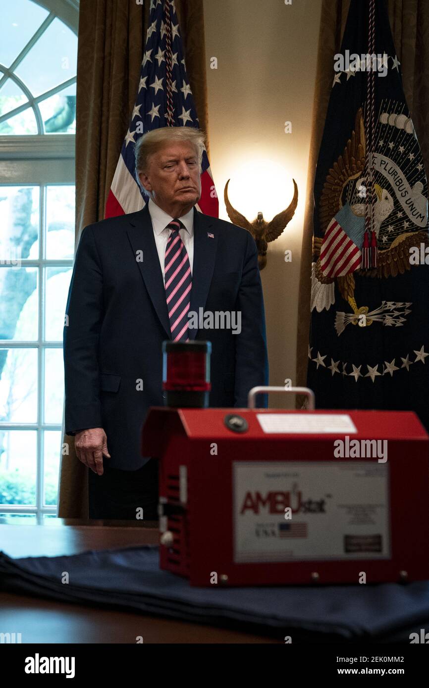 President Donald Trump looks at AMBUstat, a decontaminator device ...